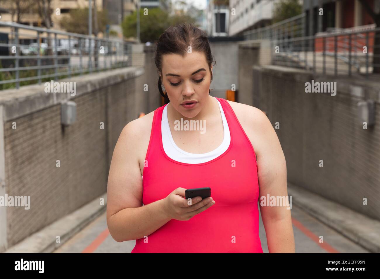 Curvy Caucasian woman using her smartphone in the city streets Stock ...