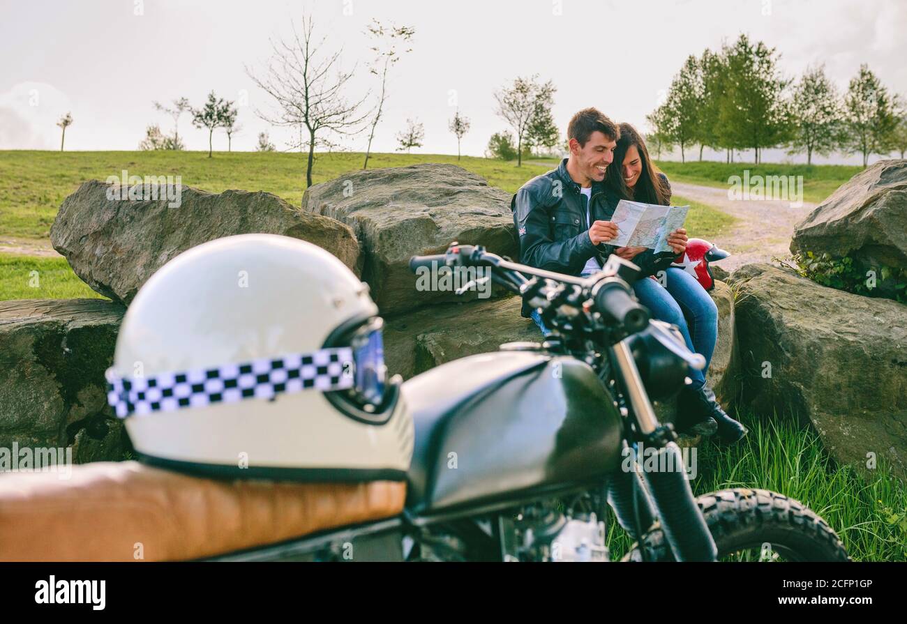 Couple sitting looking at a map with motorcycle Stock Photo - Alamy