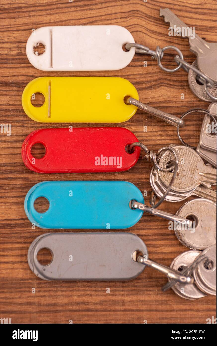 Close up of keys with colorful key rings on natural wood background ...
