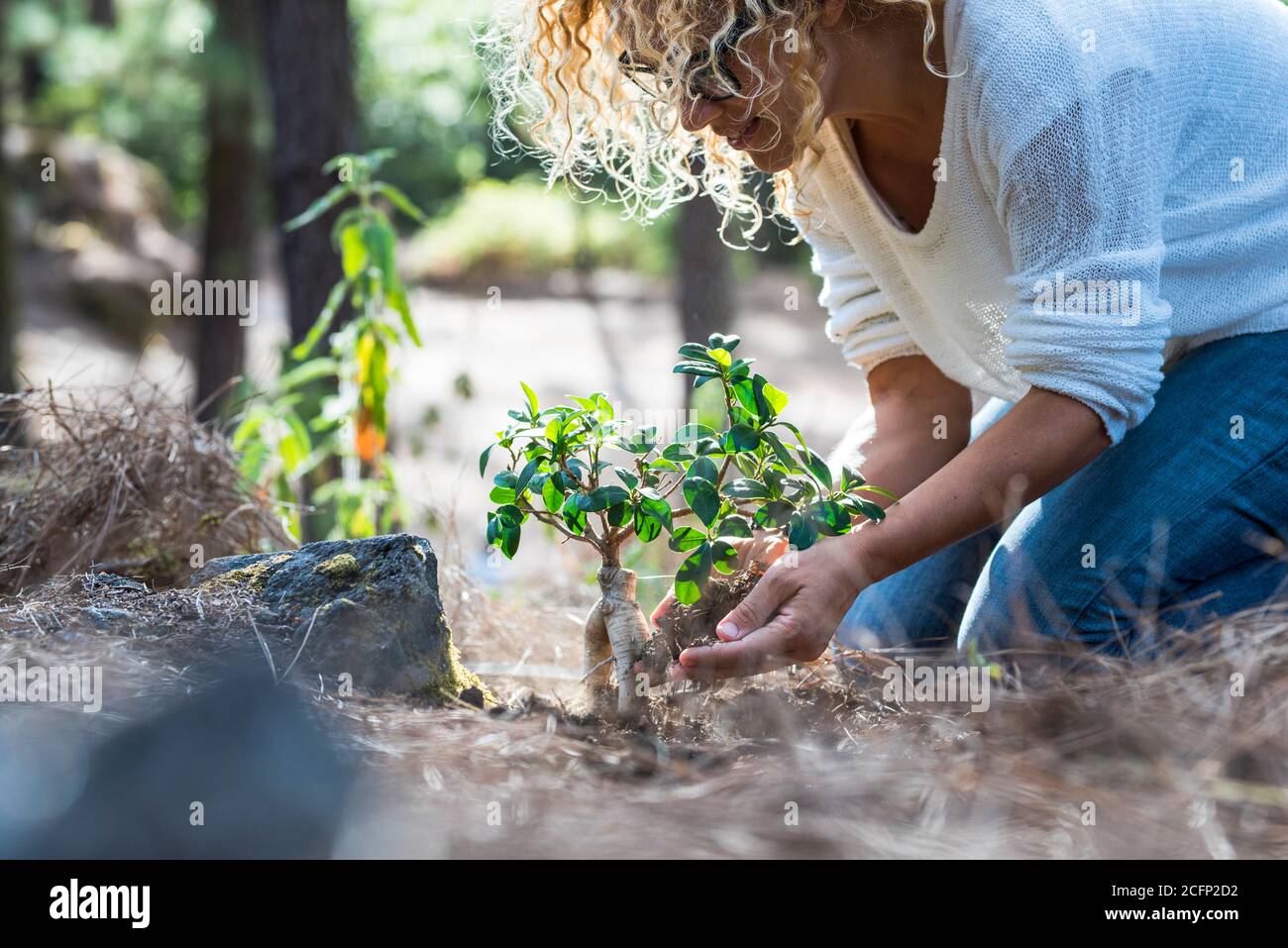 Earth's day celebration concept with happy woman planting a new tree in ...