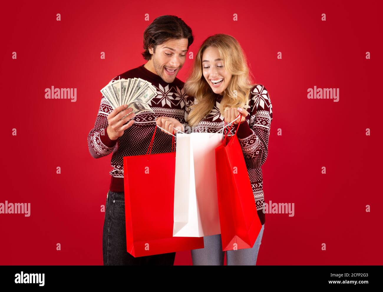 Christmas gifts. Young guy and his girlfriend with money opening ...