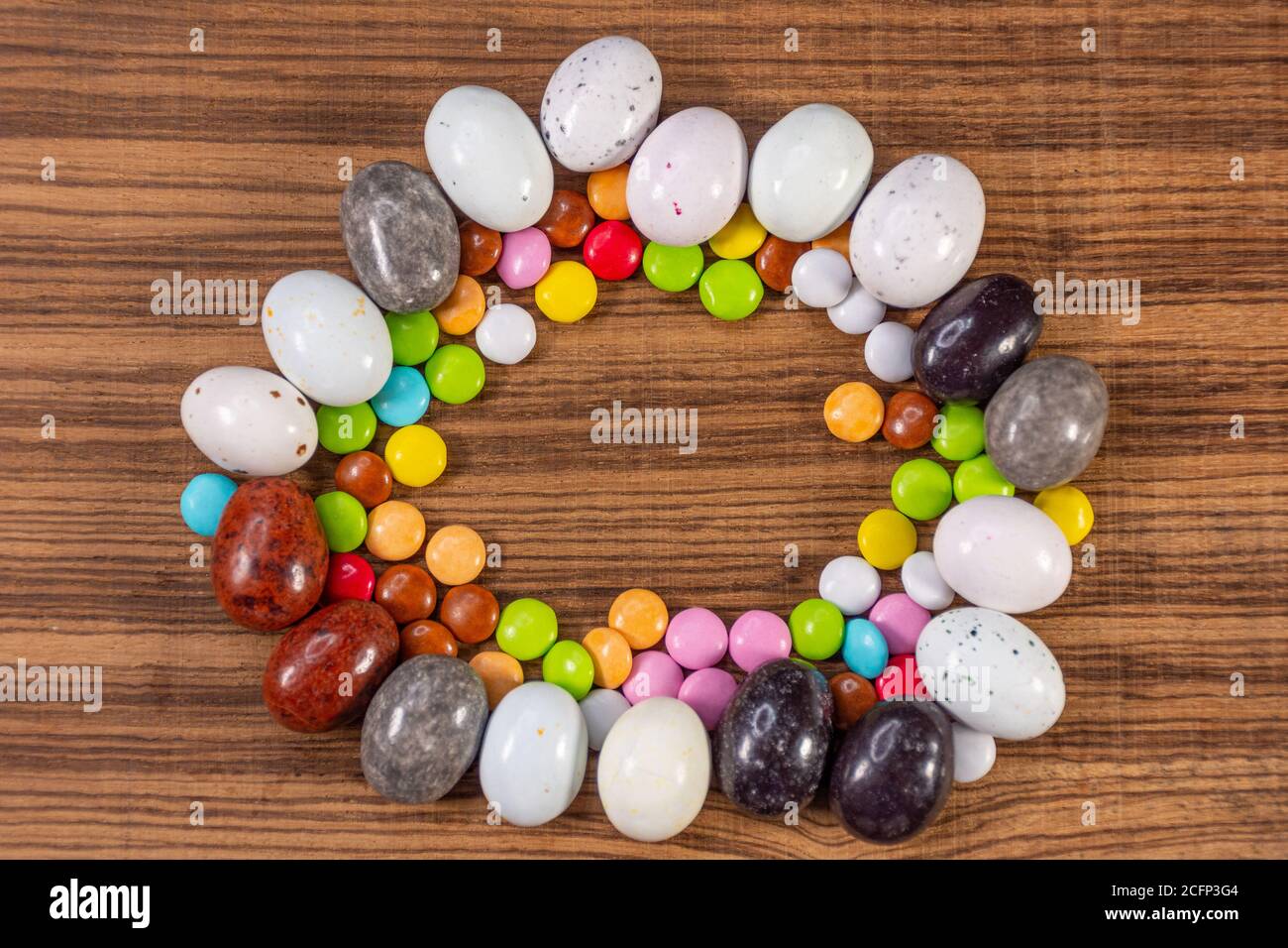 Colored eggs and colored chocolate tablets on exotic natural wood ...