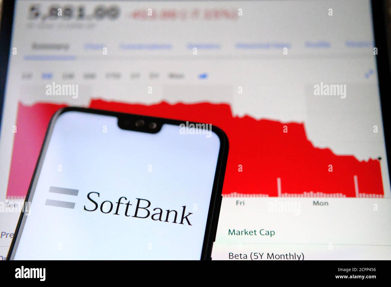 Softbank logo on the smartphone screen and share price falling chart on ...