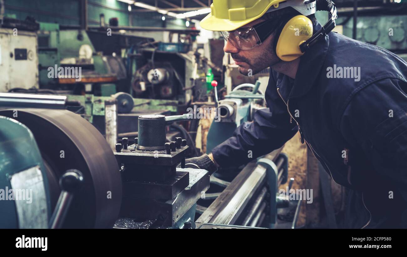 Smart factory worker using machine in factory workshop Stock Photo - Alamy