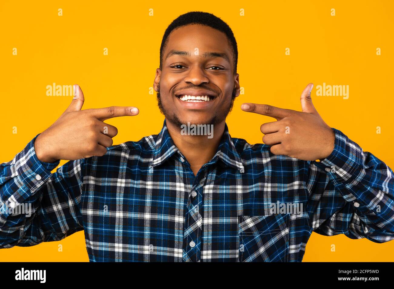 African Man Pointing Fingers At His Smile Standing In Studio Stock ...