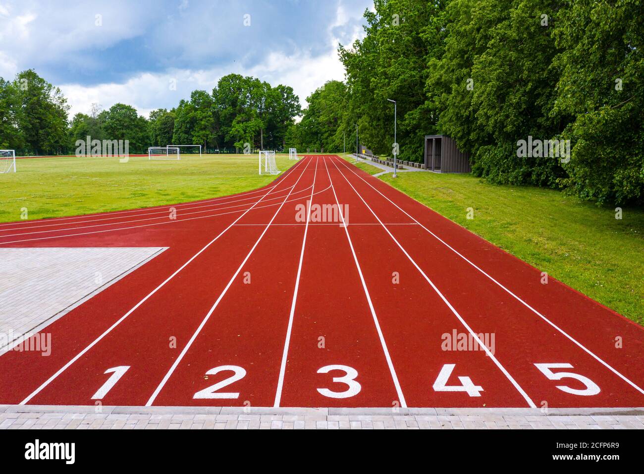 perspective view of an open - air stadium with red numbered running ...
