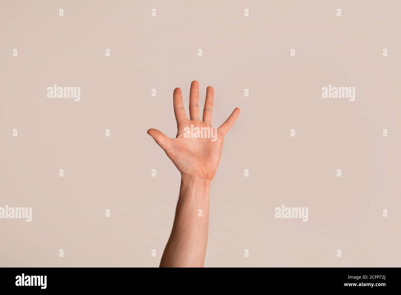 Young guy showing his hand with open palm, gesturing high five on light ...
