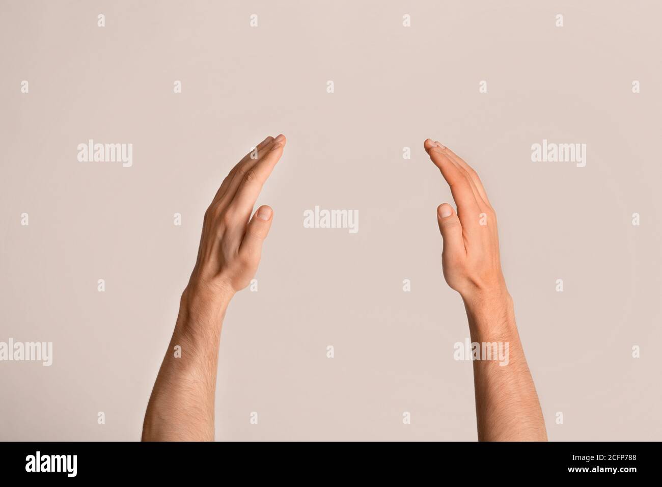 Closeup view of male hands holding something on light background ...