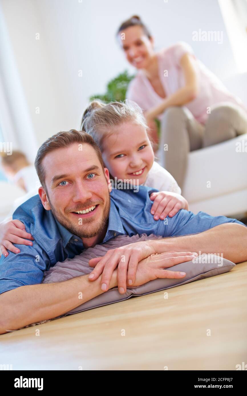 Happy parents with laughing daughter as family at home Stock Photo - Alamy
