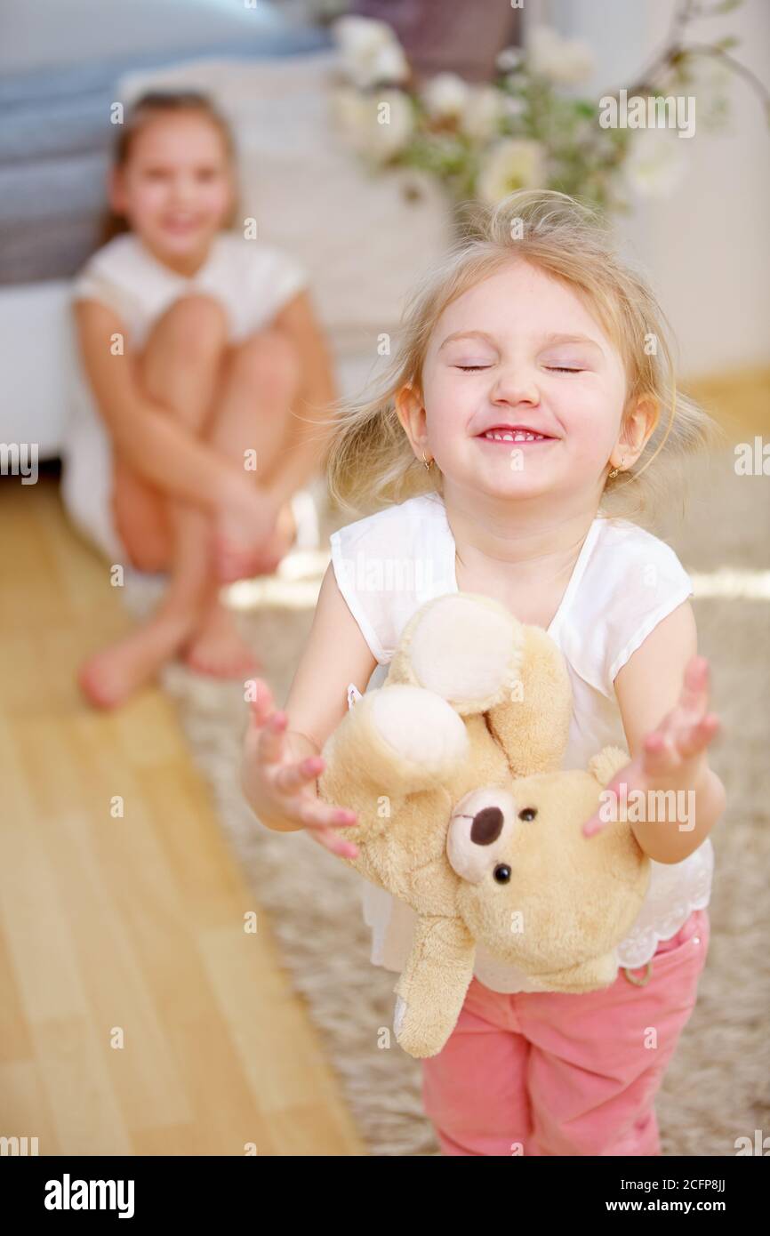 Two children play with a teddy as a cuddly toy at home Stock Photo - Alamy