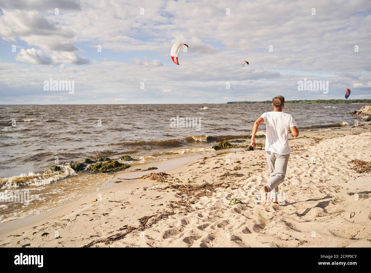 Lean man jogging in beach in solitude Stock Photo - Alamy