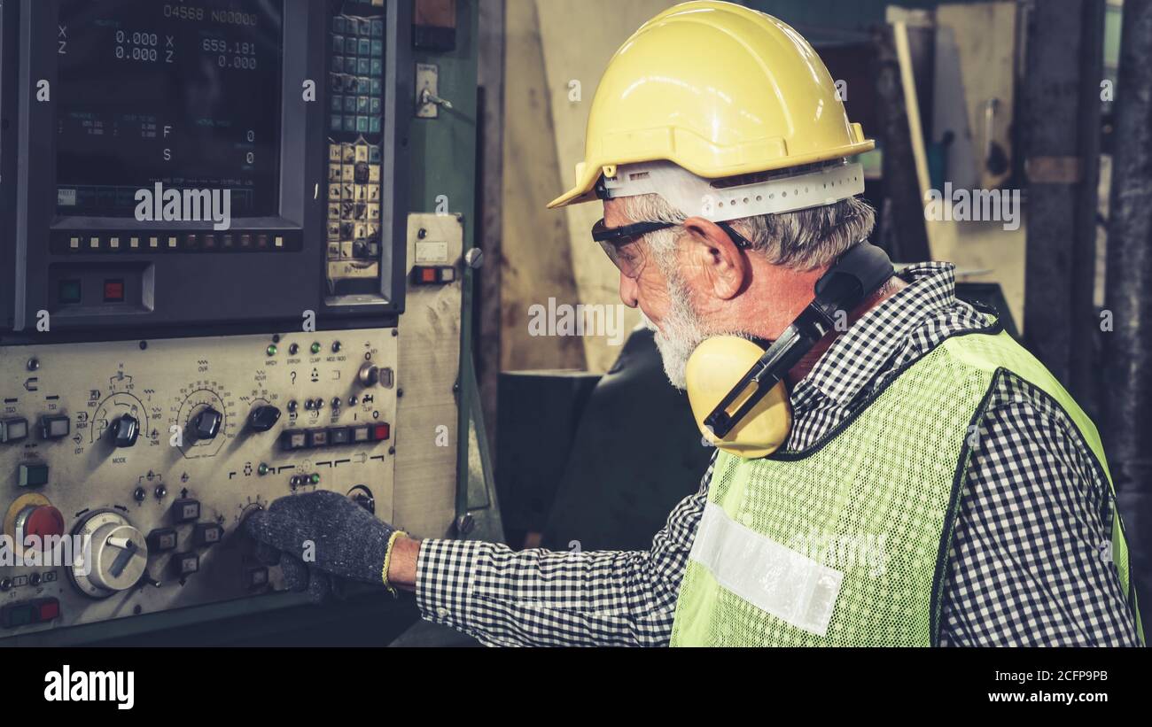 Smart factory worker using machine in factory workshop Stock Photo - Alamy