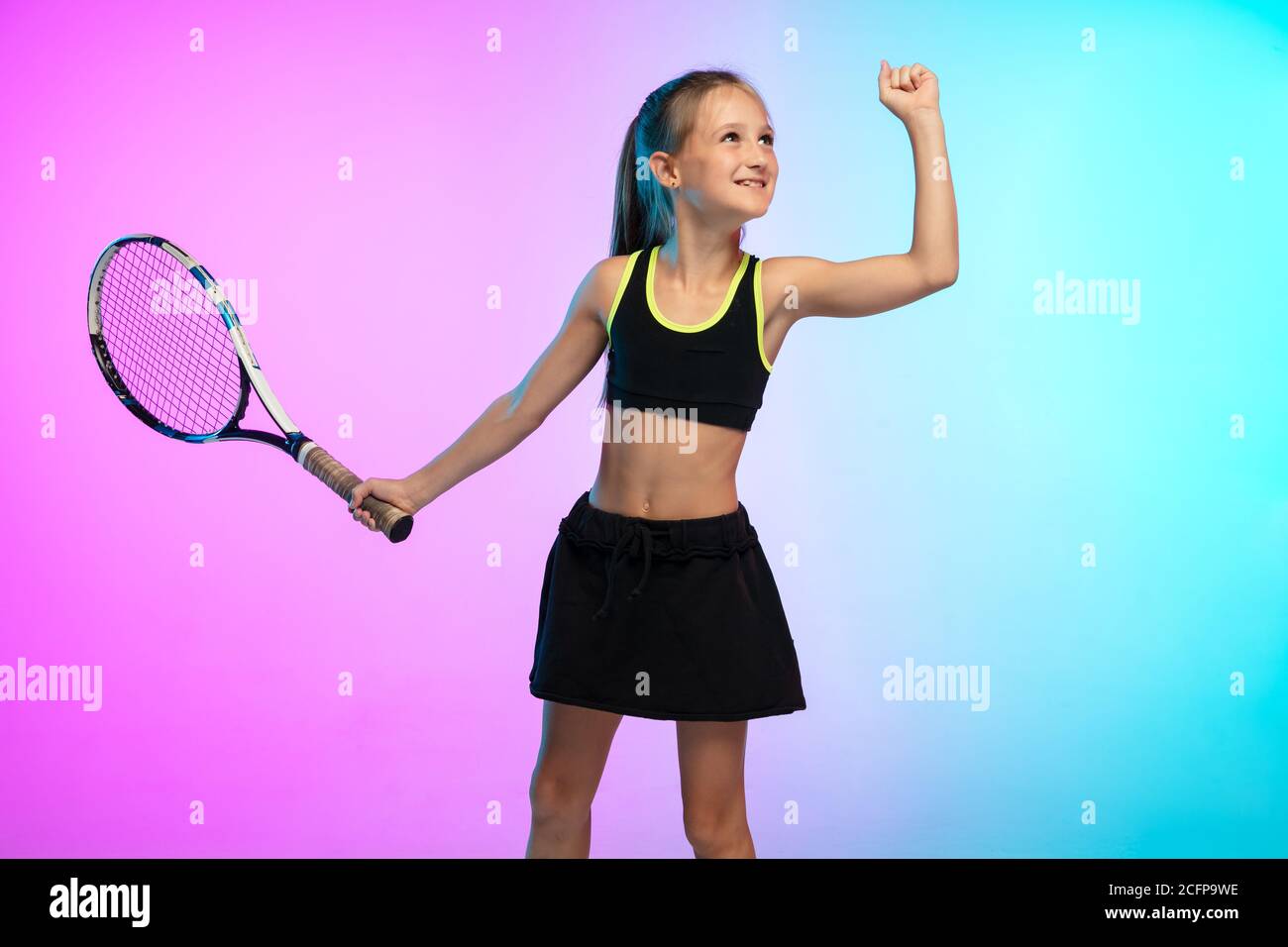 Winner. Little tennis girl in black sportwear isolated on gradient ...