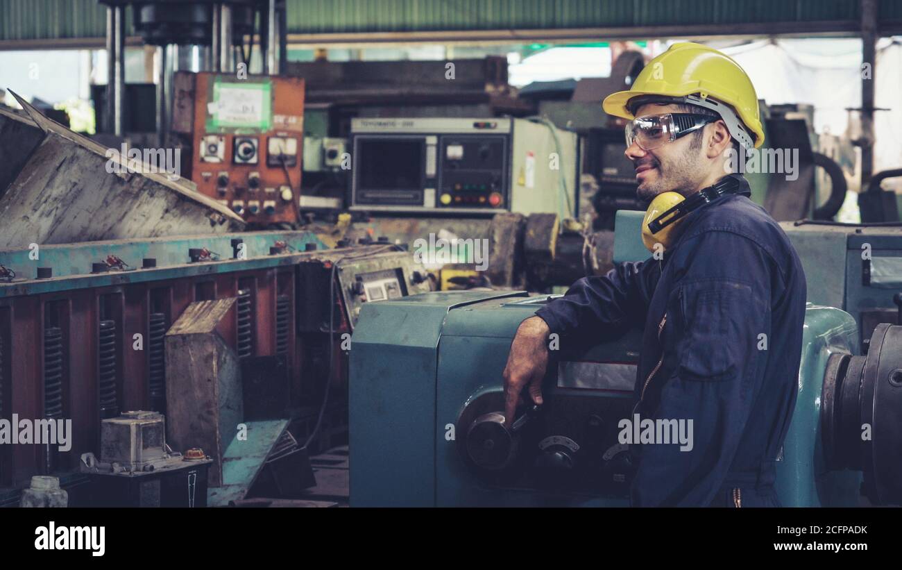 Smart factory worker using machine in factory workshop Stock Photo - Alamy