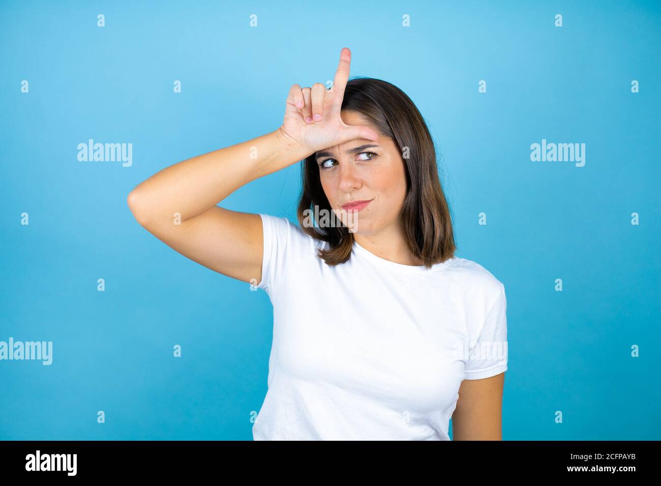 Young beautiful woman over isolated blue background making fun of ...