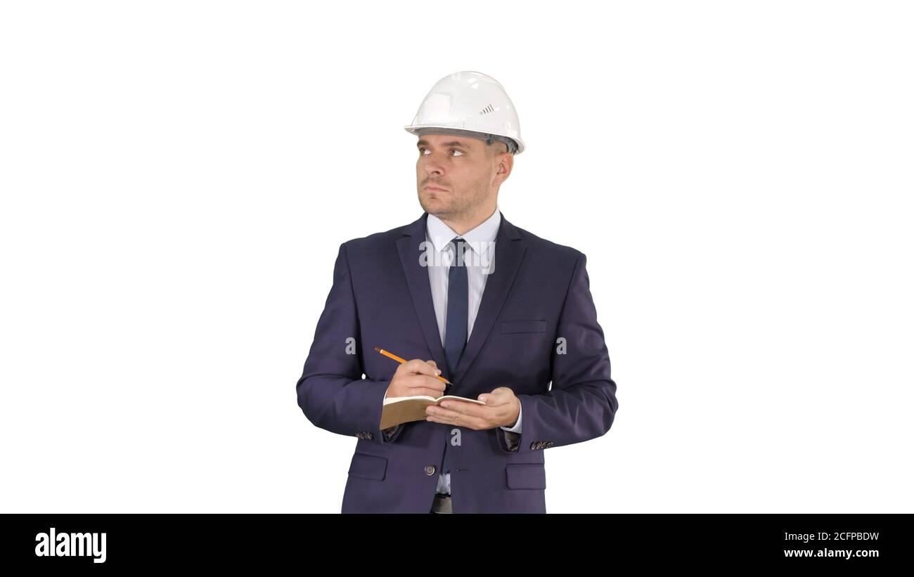 Engineer in suit and helmet walking and writing notes in notepad on ...
