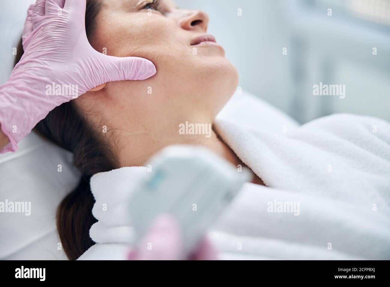 Calm patient being treated by a professional dermatologist Stock Photo ...