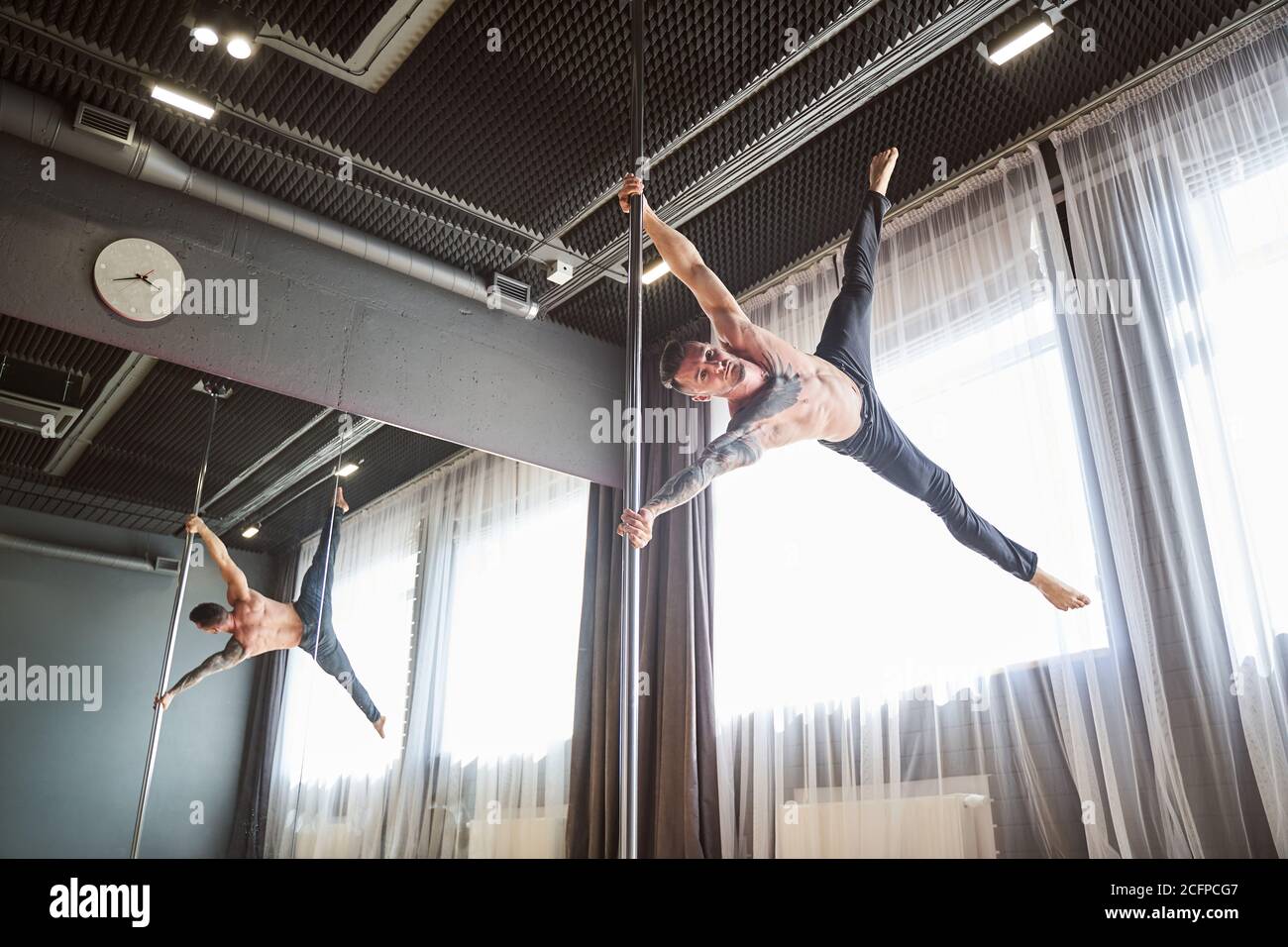 Muscular man dancing in a class with big window Stock Photo - Alamy