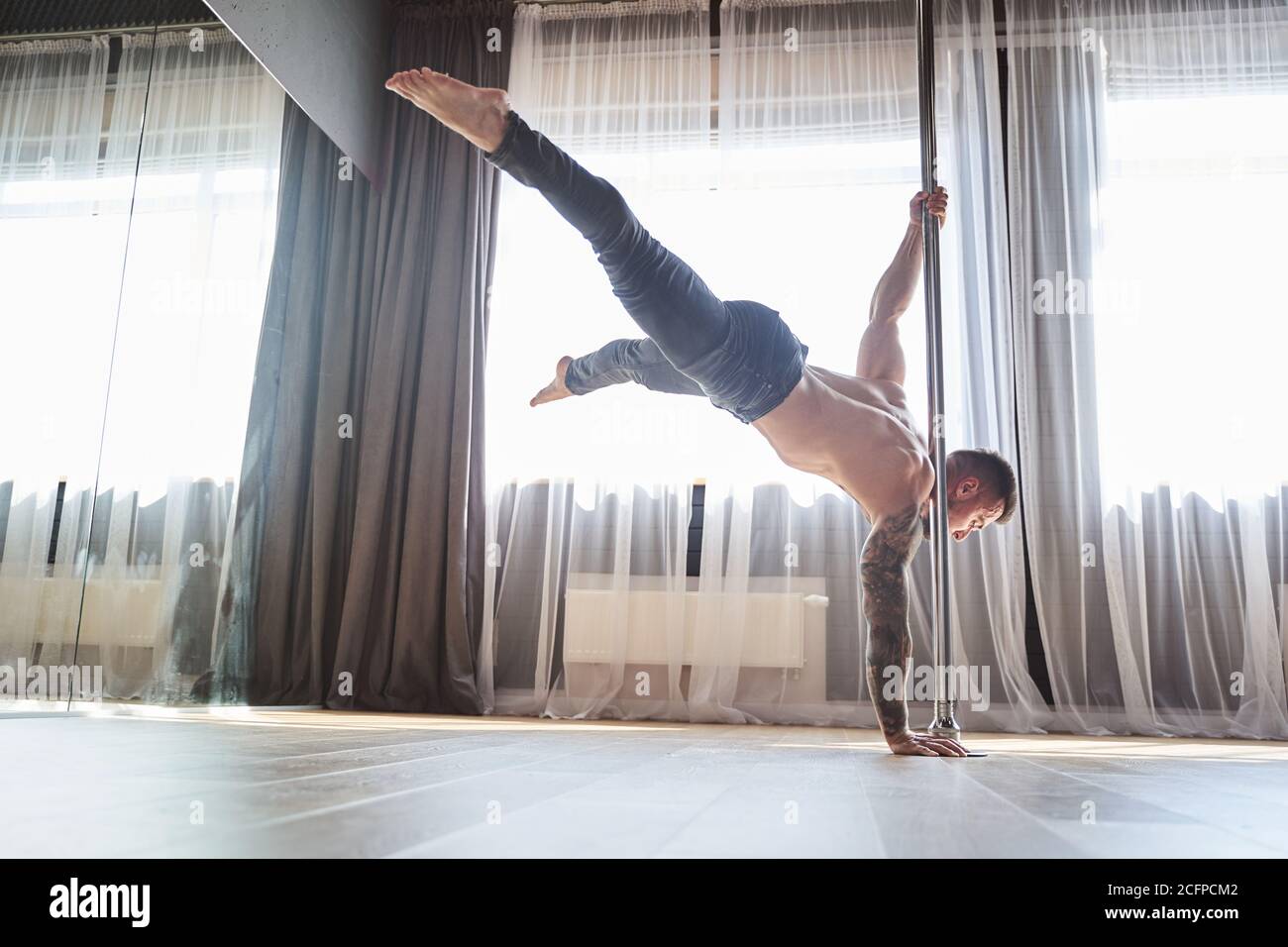 Attractive young man dancing in studio on pylon Stock Photo - Alamy