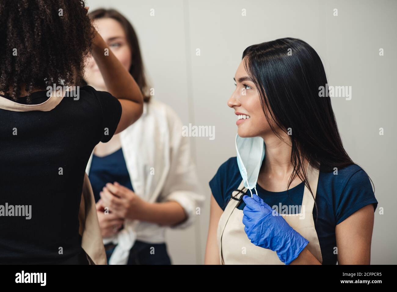 Group of beauty masters taking off protective masks in beauty salon ...