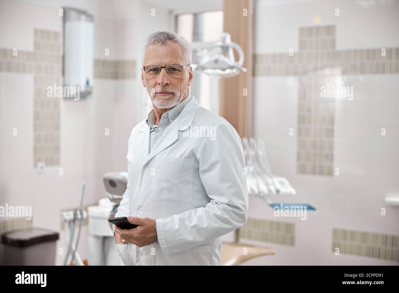 Professional dentist standing proudly in his office Stock Photo - Alamy