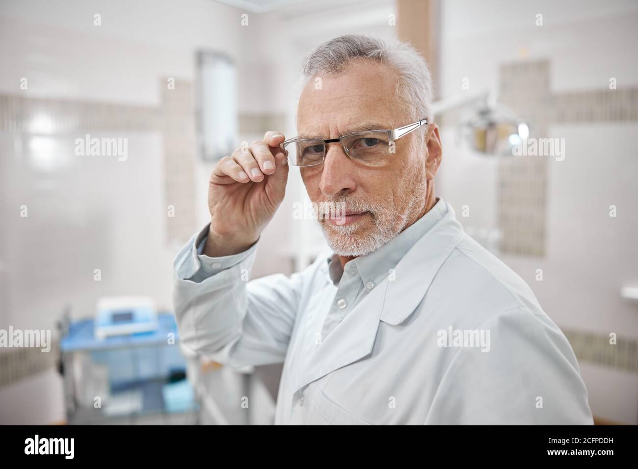 Professional dentist proudly posing in his dental clinic Stock Photo ...