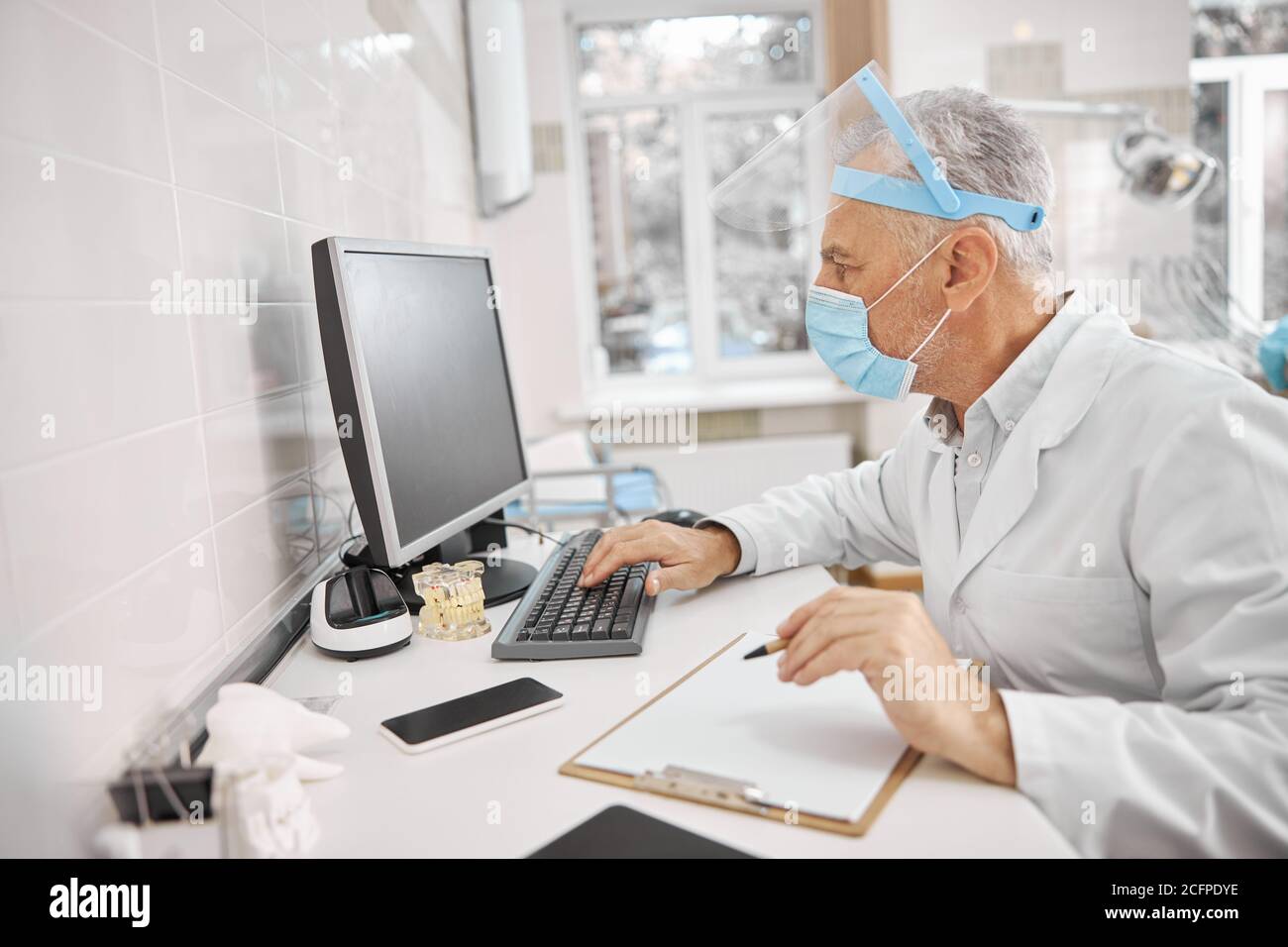 Busy healthcare professional looking at a computer screen Stock Photo ...