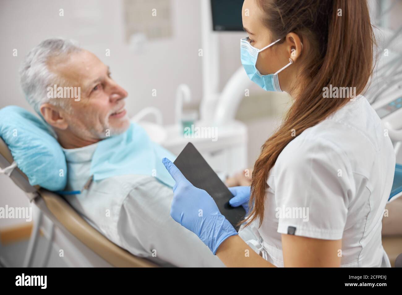 Professional young dental expert ready to begin dental examination ...