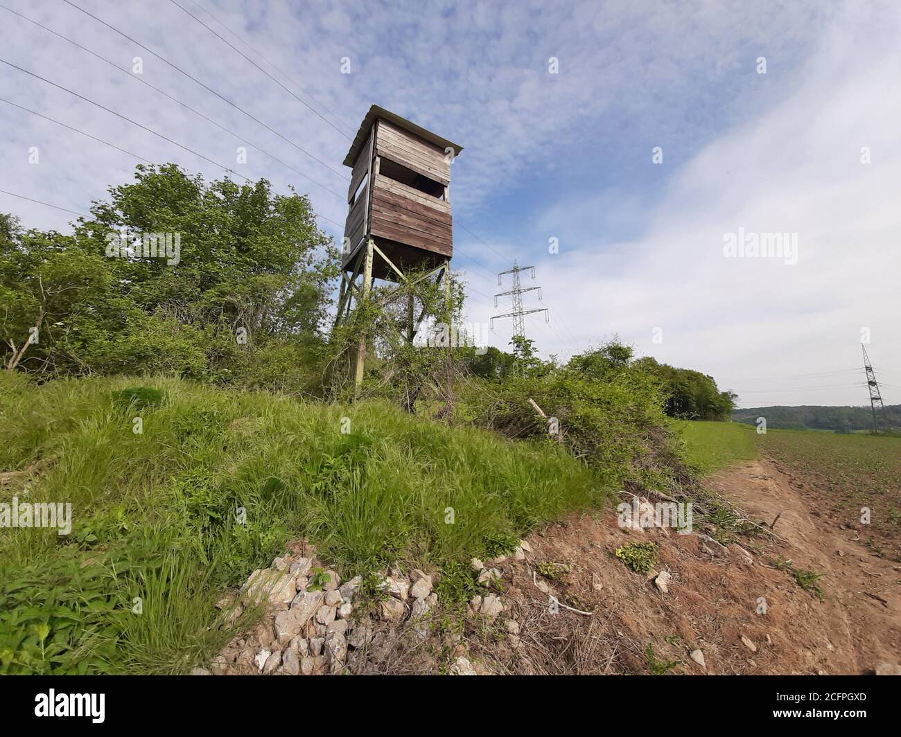 raised hide between high-voltage overhead line and field, Germany Stock ...