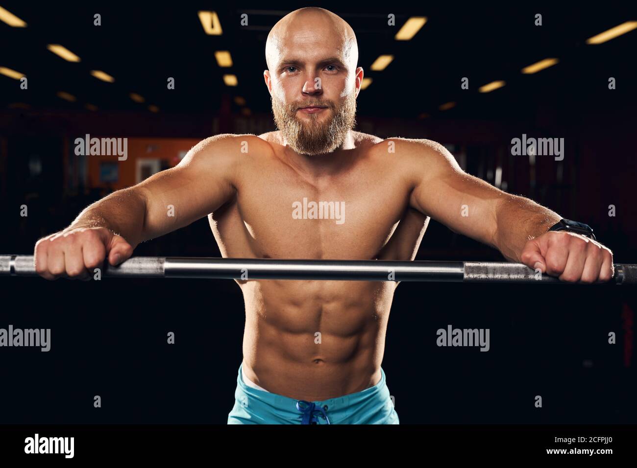 Muscled young man standing near gym equipment Stock Photo - Alamy