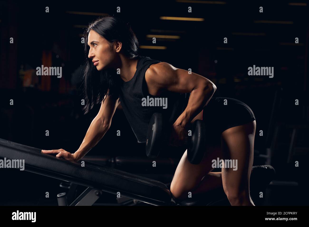 Strong lady using dummbells to exercise on an incline bench Stock Photo ...