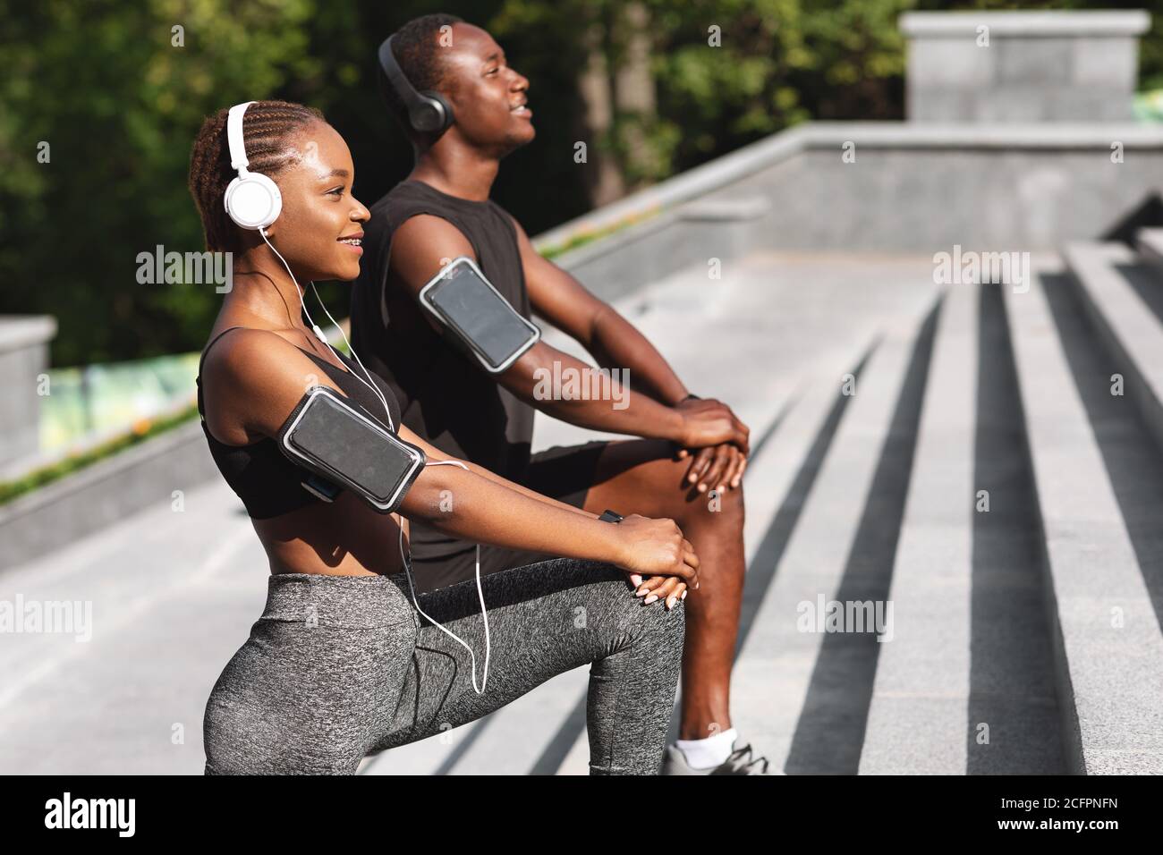 Sporty African Couple Doing Stretching Exercises Outdoors In City Park ...