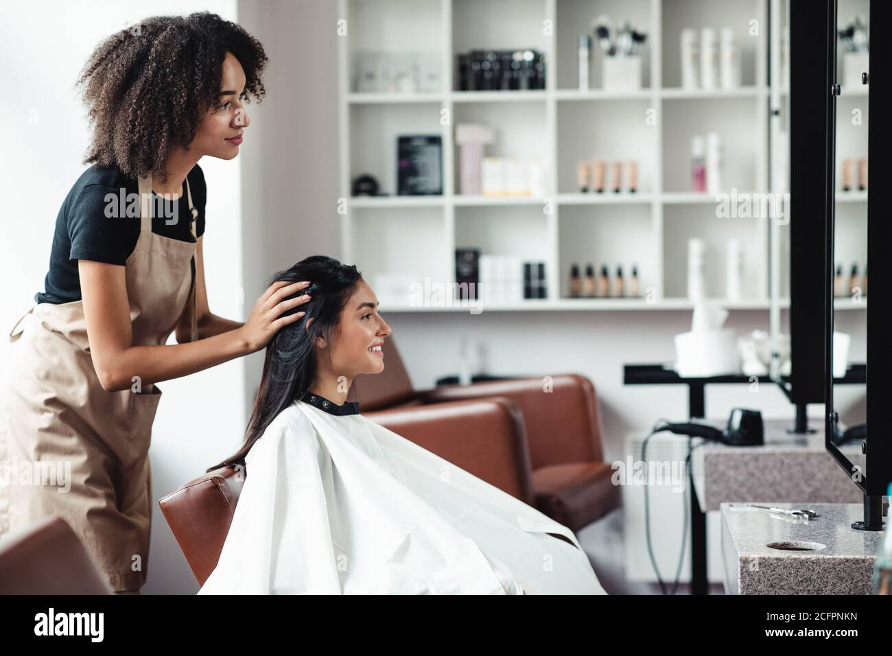 Young woman looking for changes, trying new hairstyle at beauty salon ...