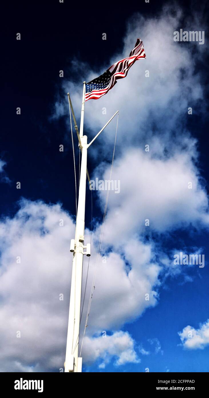 American flag billowing against blue sky and white clouds Stock Photo ...