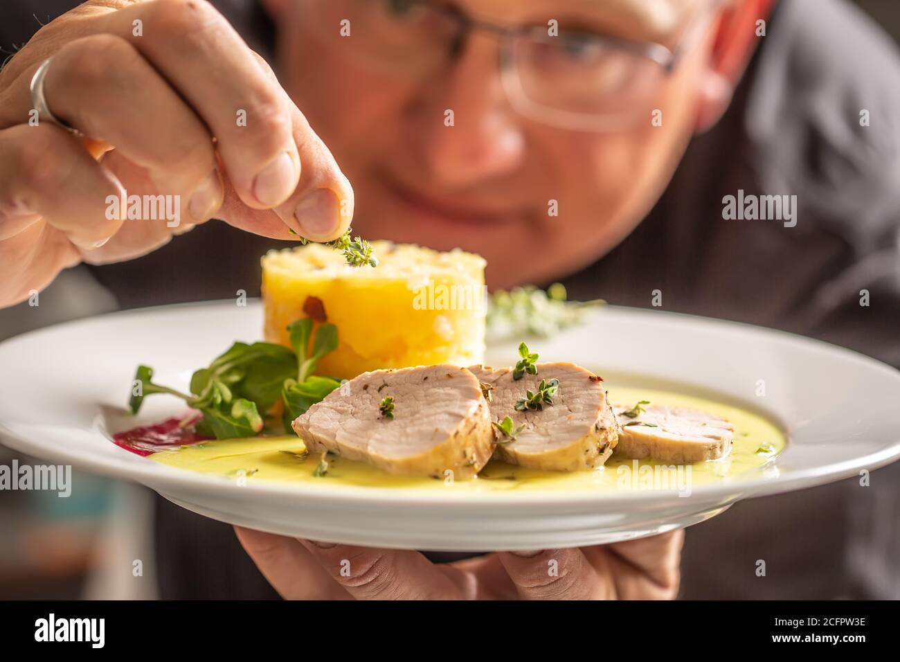 Chef in hotel or restaurant kitchen cooking only hands. He is working ...