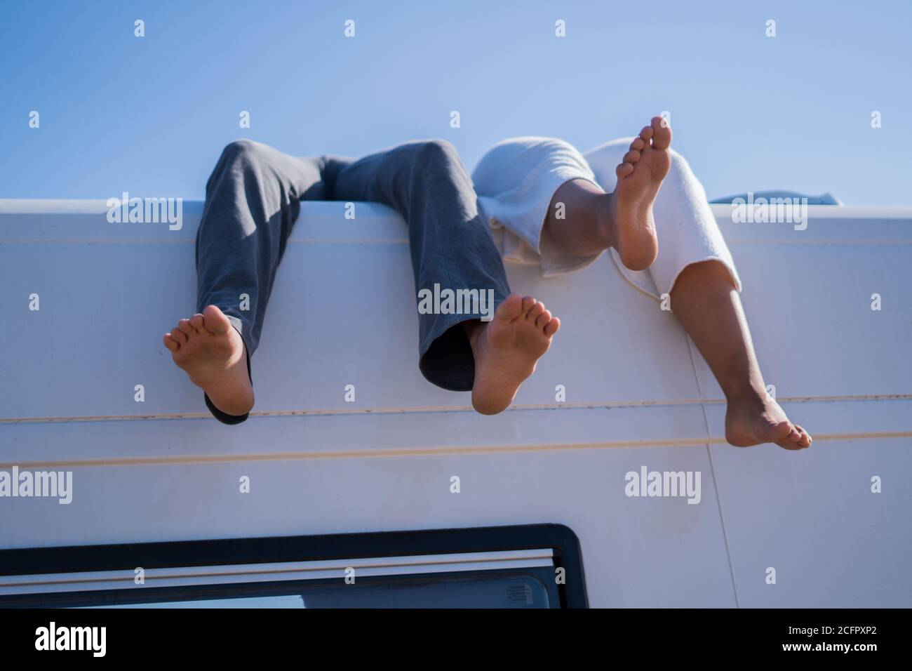Low angle shot of feet hanging from on top of a bus Stock Photo - Alamy