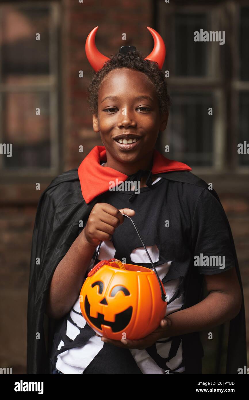 Vertical medium portrait of happy African American boy dressed up as ...