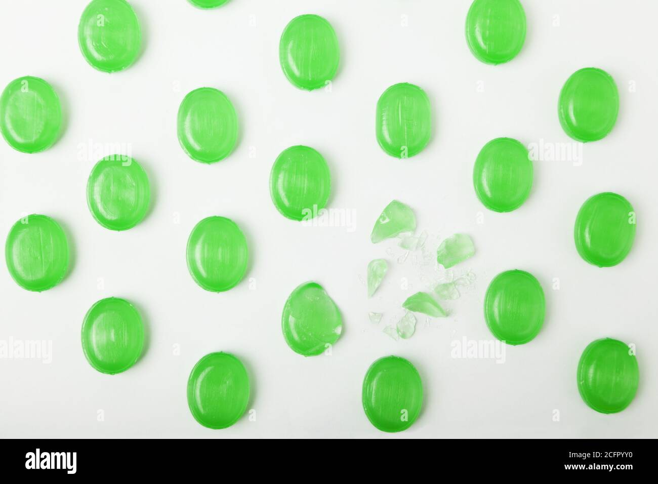 Bunch of green cough lozenges with one smashed Stock Photo - Alamy