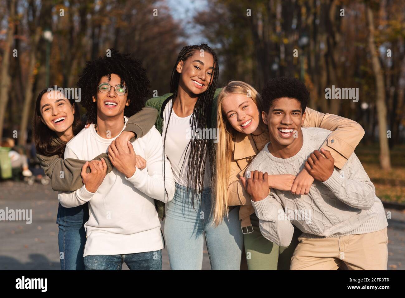 Positive group of young friends having fun at public park Stock Photo ...