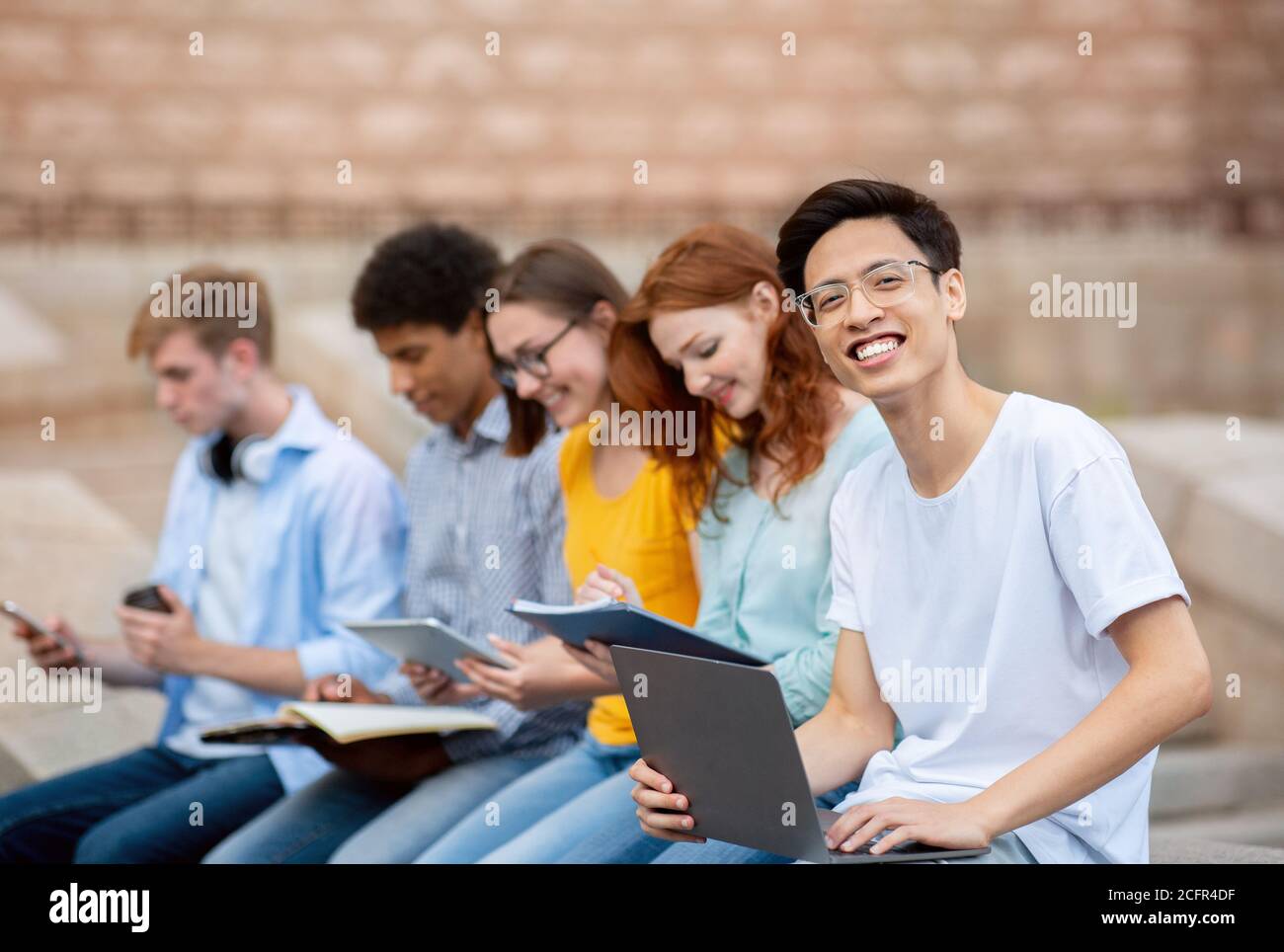 Asian Student Learning With Coursemates Sitting Outside University ...