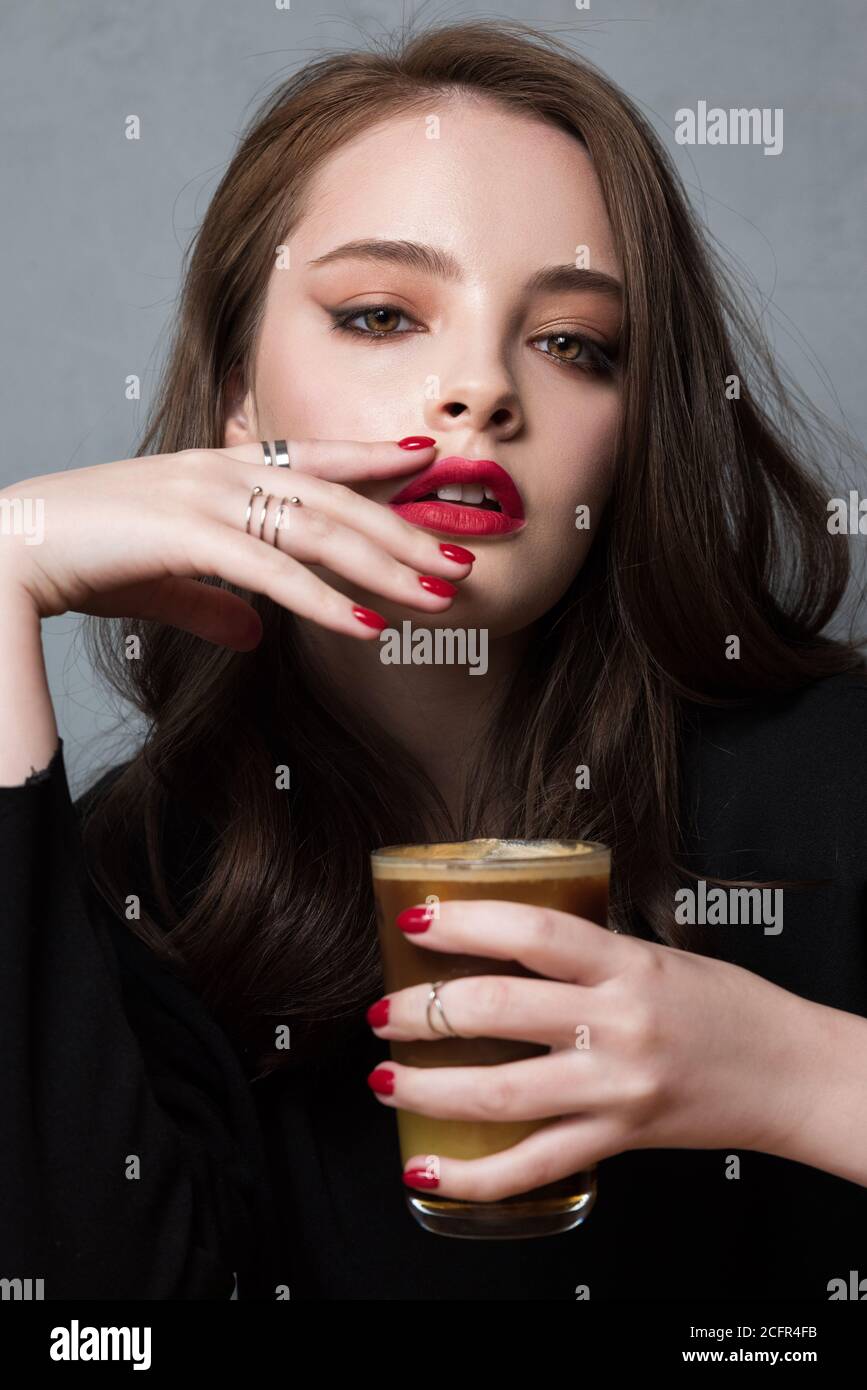 Closeup beauty portrait of a young woman with a perfect red manicure ...