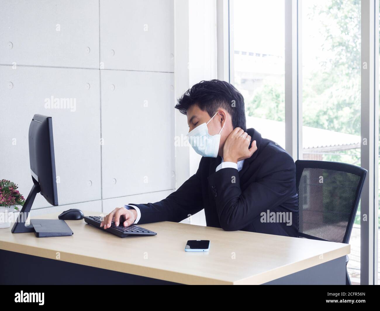 Young Asian businessman in suit wearing medical face mask getting hand ...