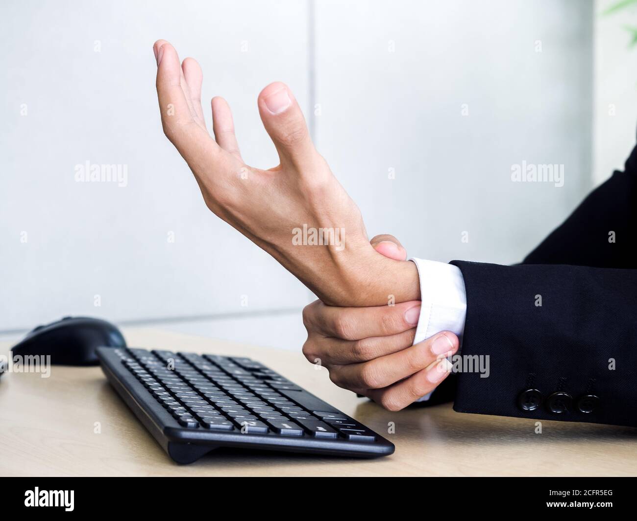 Close-up businessman in suit getting hand pain while using notebook ...