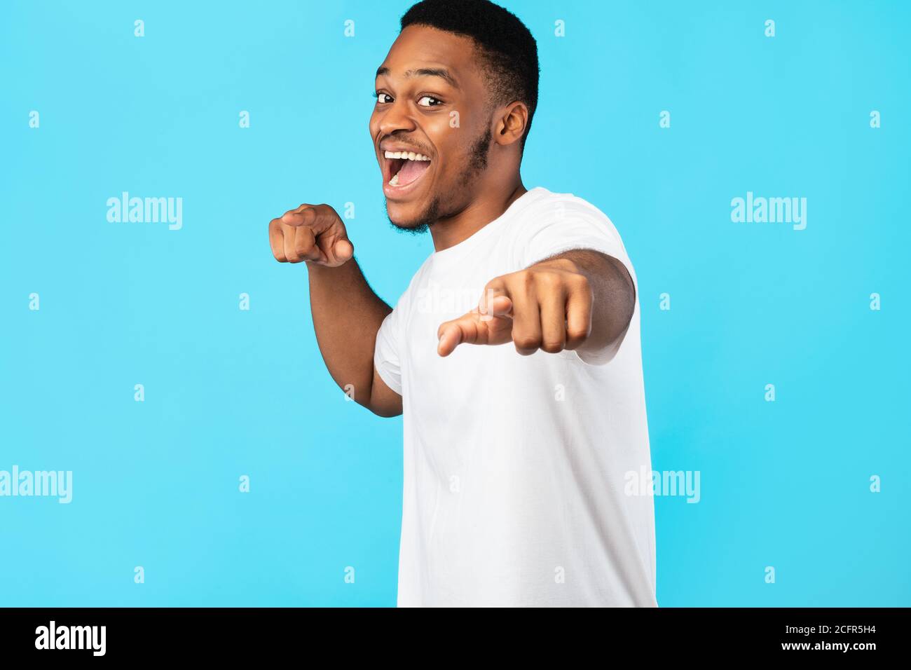 Black Man Pointing Fingers At Camera Over Blue Studio Background Stock ...