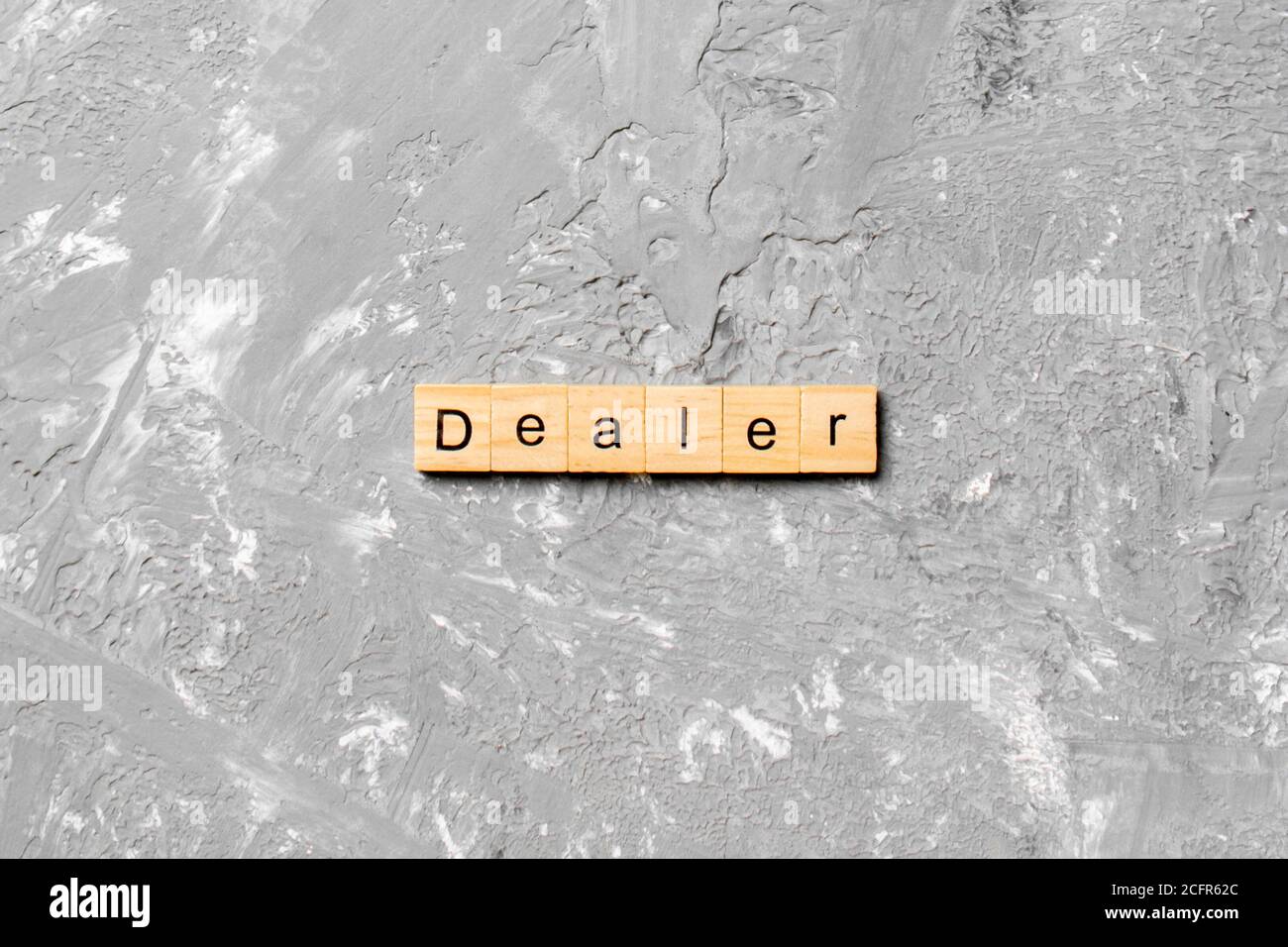 Dealer word written on wood block. Dealer text on cement table for your ...