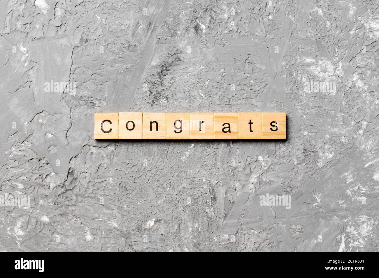 Congrats word written on wood block. Congrats text on cement table for ...