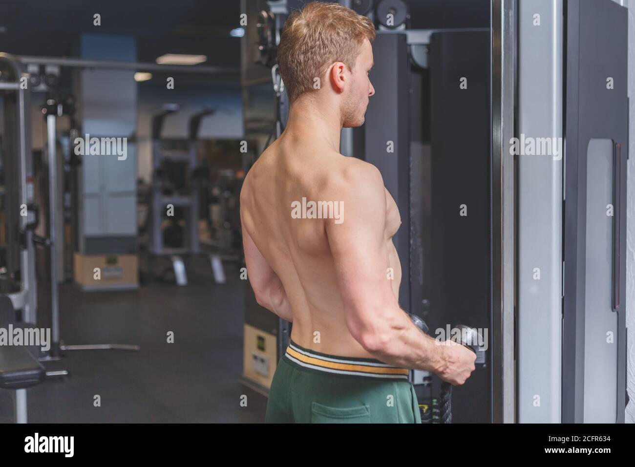 Strong shirtless male athlete concentrated on an excersise on a hand ...