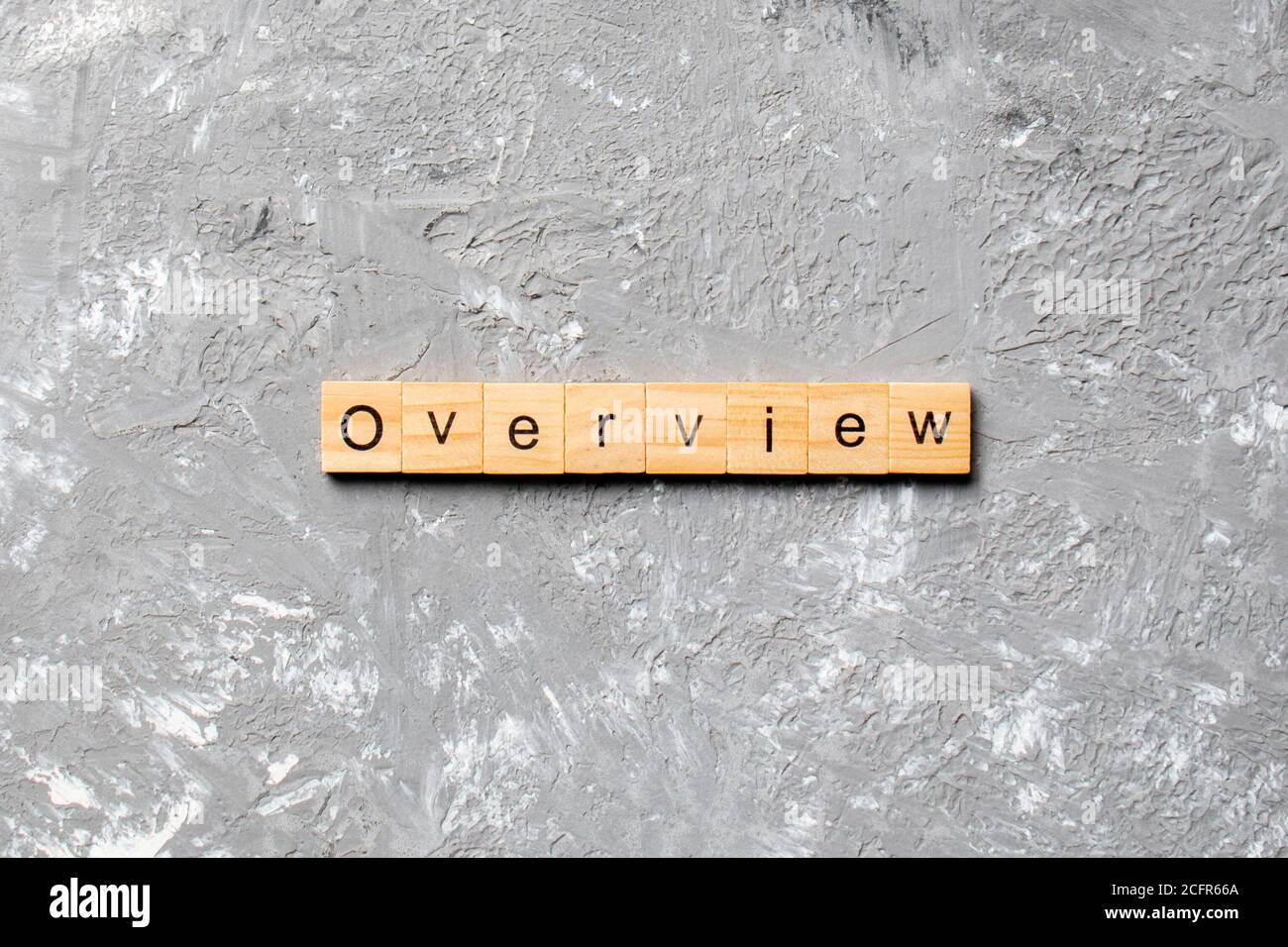 OVERVIEW word written on wood block. OVERVIEW text on cement table for ...