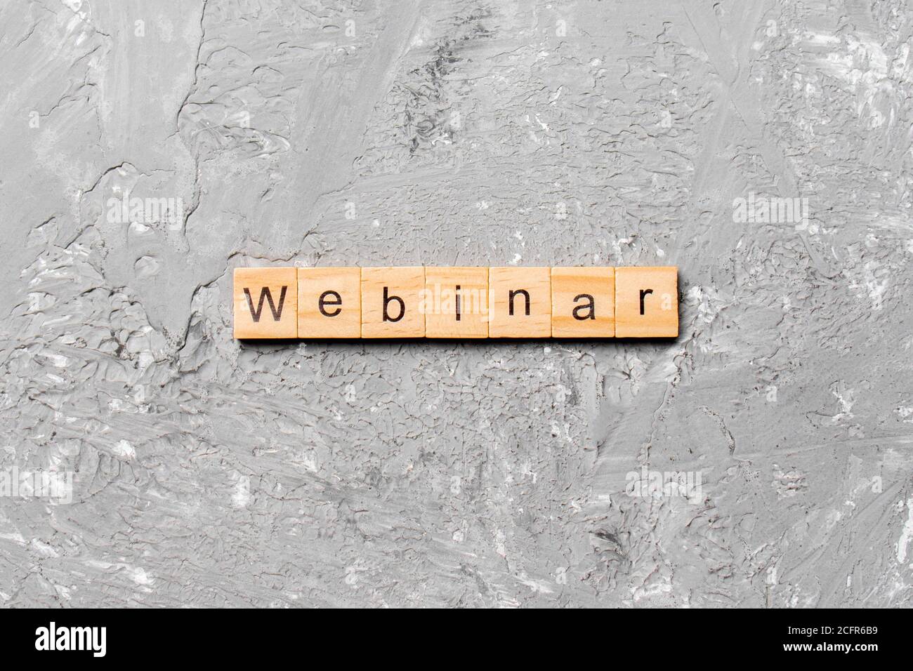 WEBINAR word written on wood block. WEBINAR text on cement table for ...
