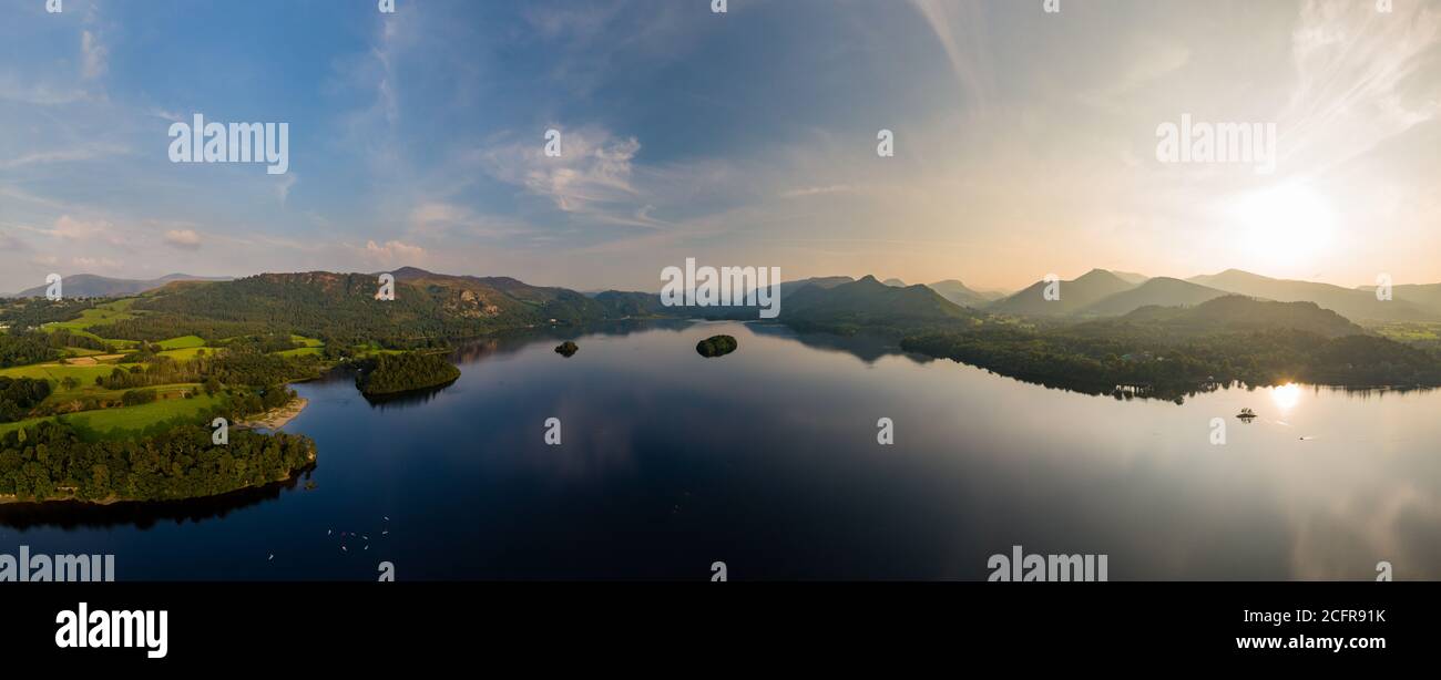 Aerial panorama of sunset next to a beautiful, flat calm lake ...